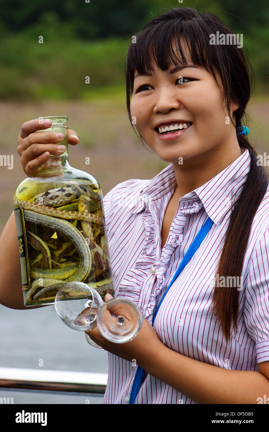 Chinese lady attempting to sell snake wine to tourists Stock Photo - Alamy