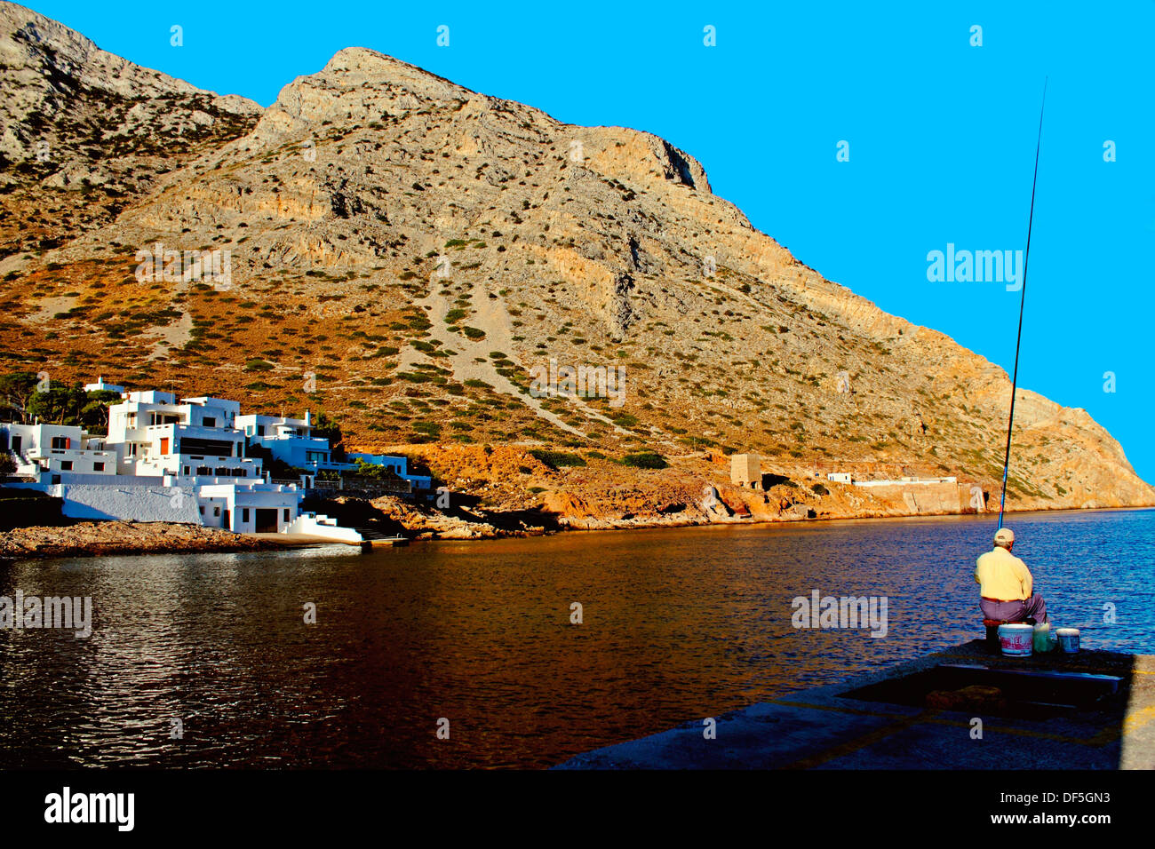 Greece, Cyclades islands, Sifnos, man fishing at Kamares, the port of ...