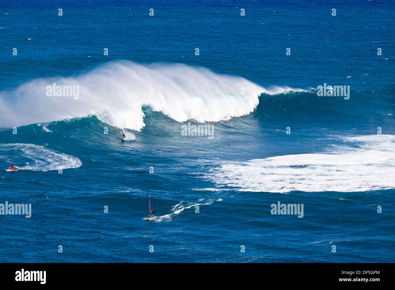 A kitesurfer in a tall wave at the famous surf spot Peahi Jaws in Maui ...
