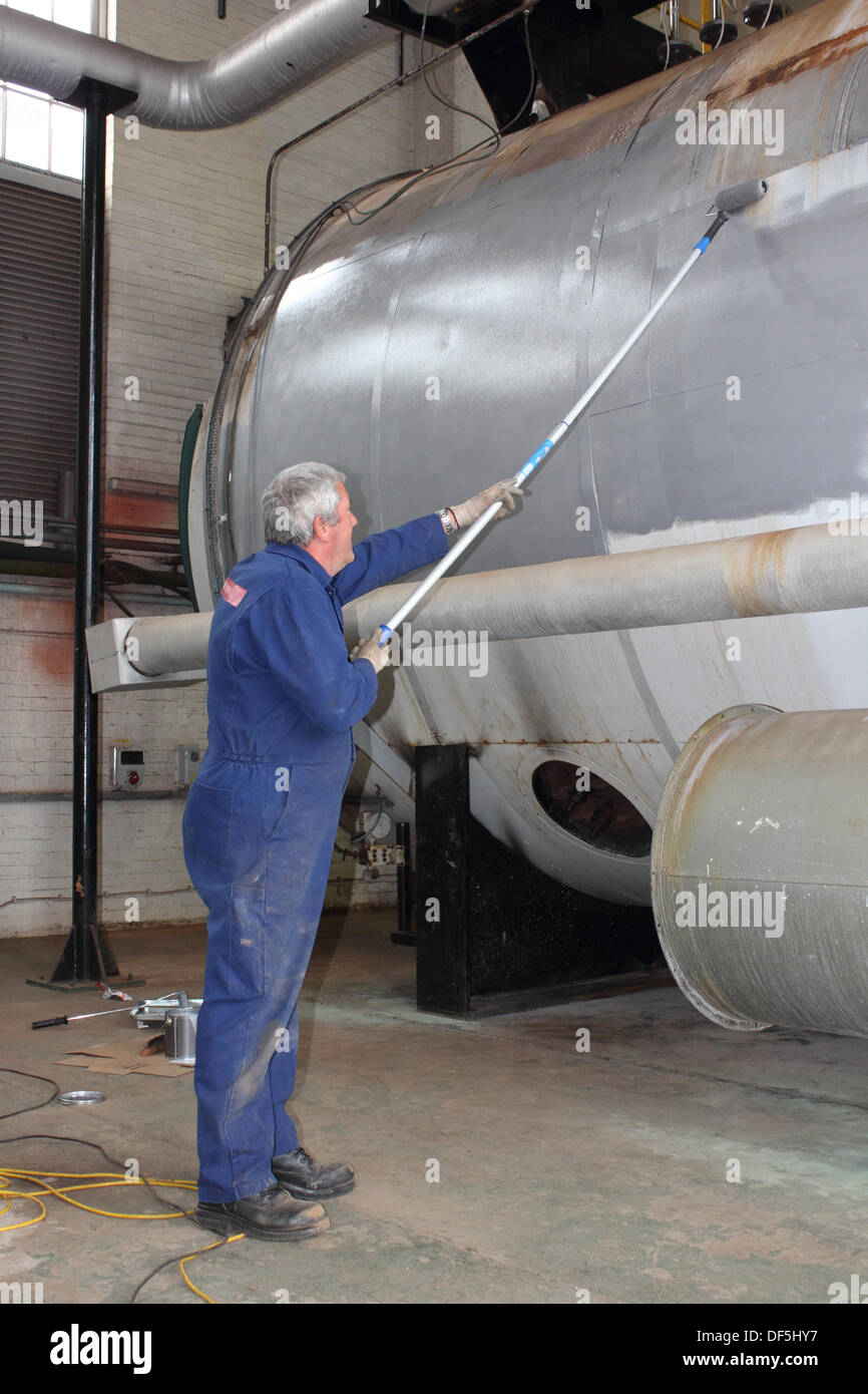 Painting a large steam boiler after a refit Stock Photo - Alamy