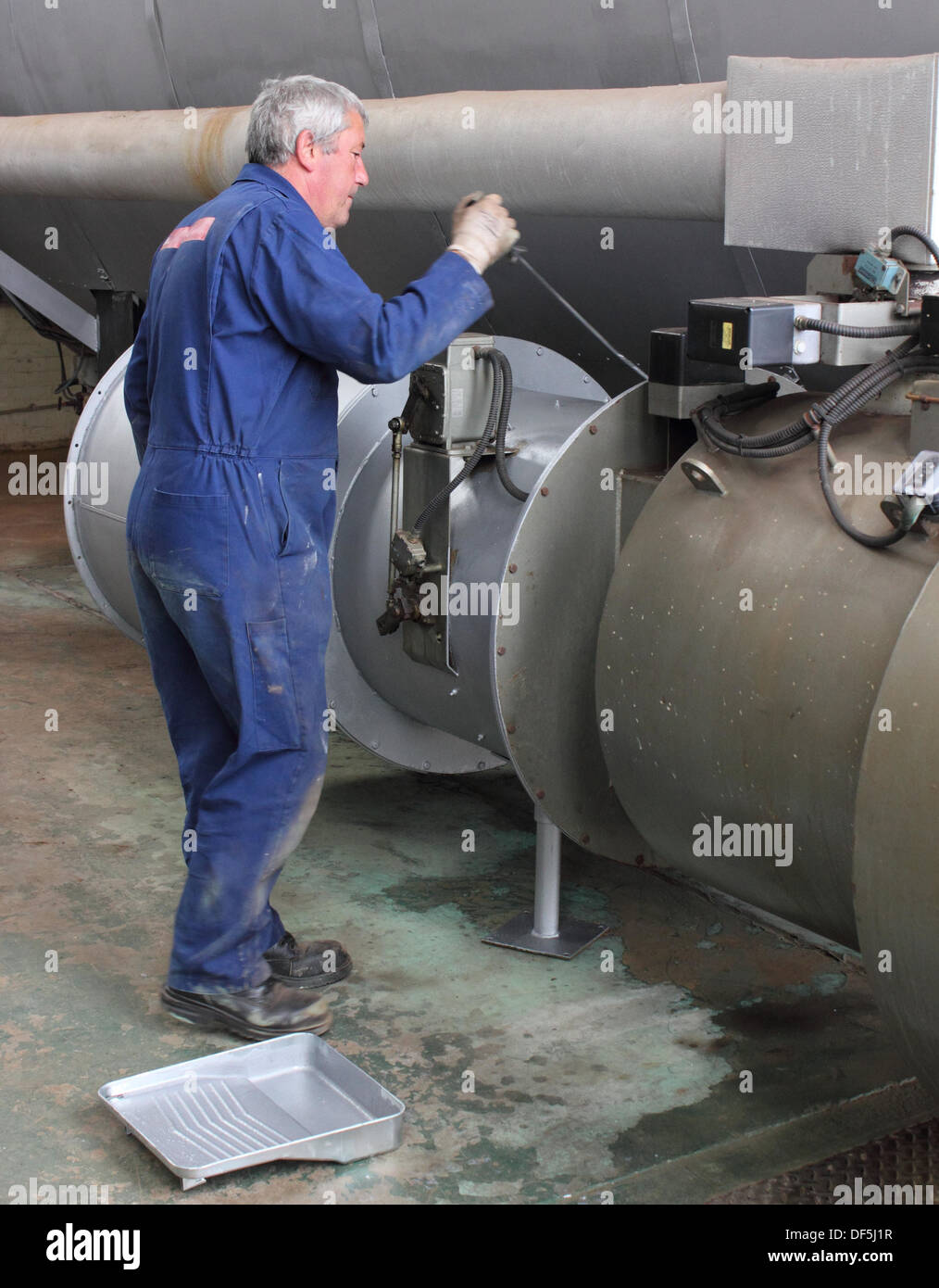 Painting a large steam boiler after a refit Stock Photo - Alamy