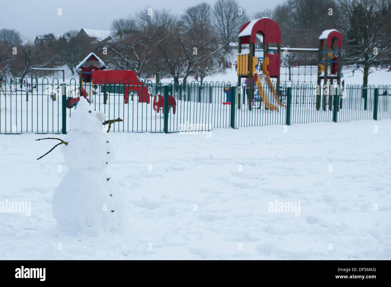 Cold winter scene with solitary snowman standing by children's play ...