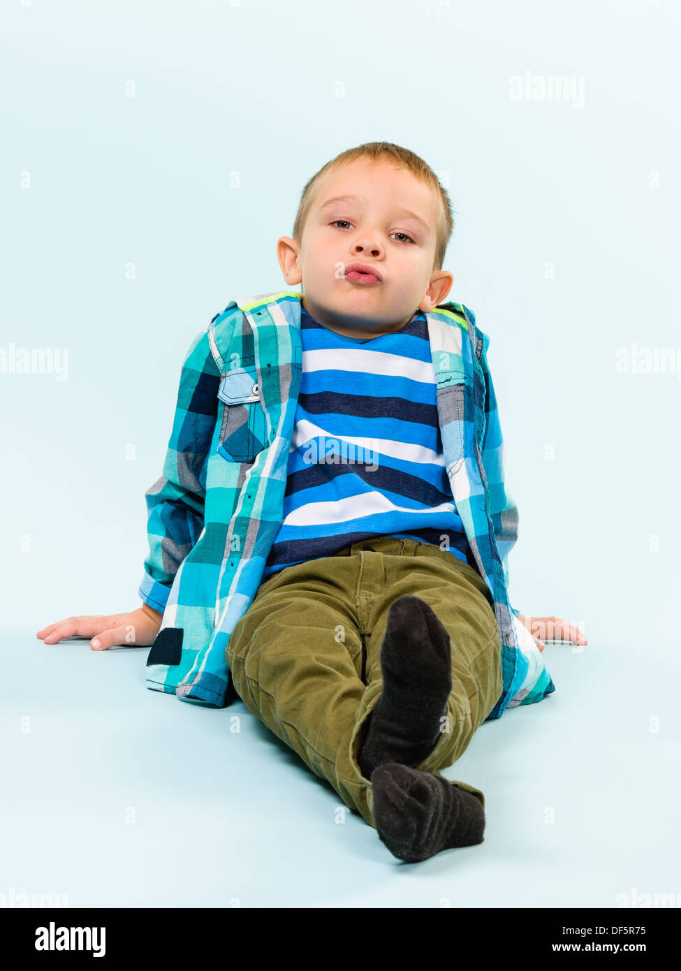 Playful little boy on studio, light blue background Stock Photo - Alamy