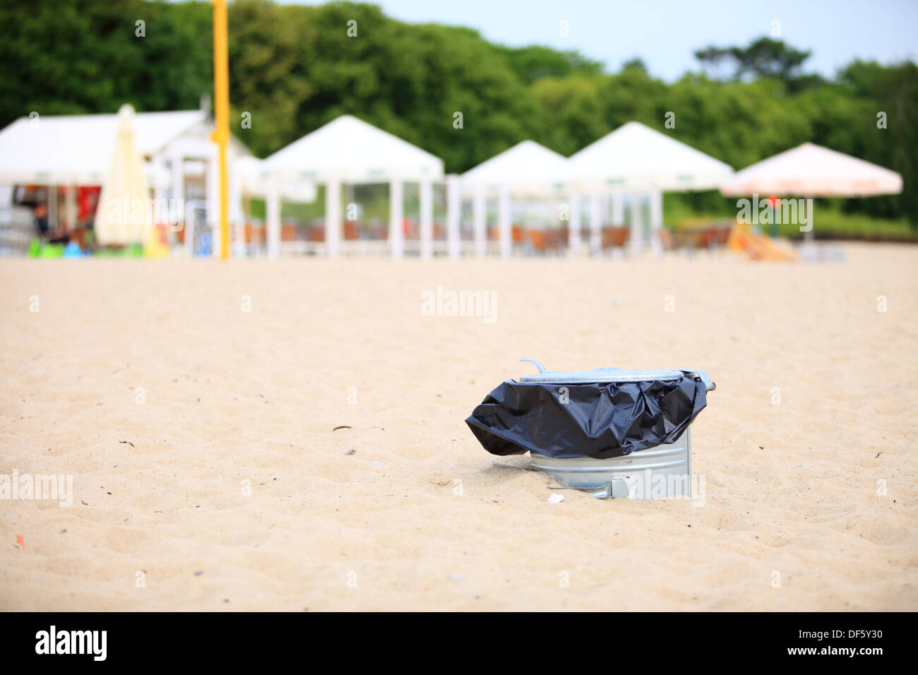 Gray metal garbage bin or trash can with a plastic bag inside beach ...