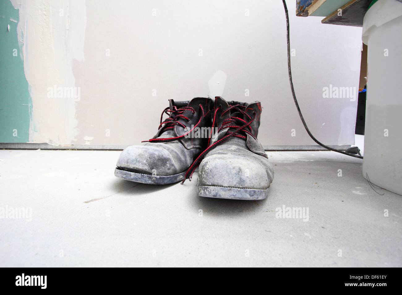 pair of old dirty work boots in construction site Stock Photo - Alamy