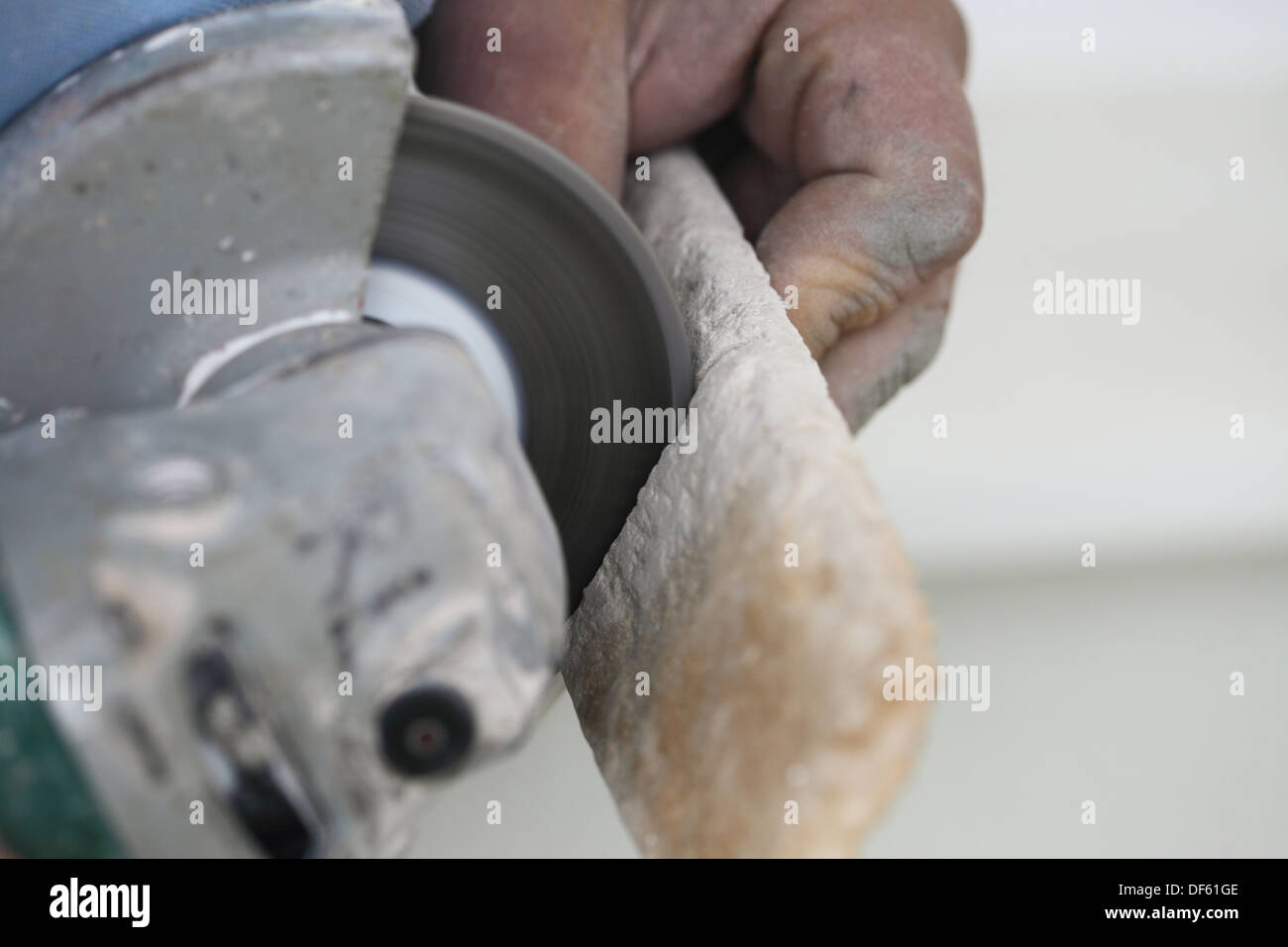 Renovation at home worker cuts tile with angle grinder electric tool ...