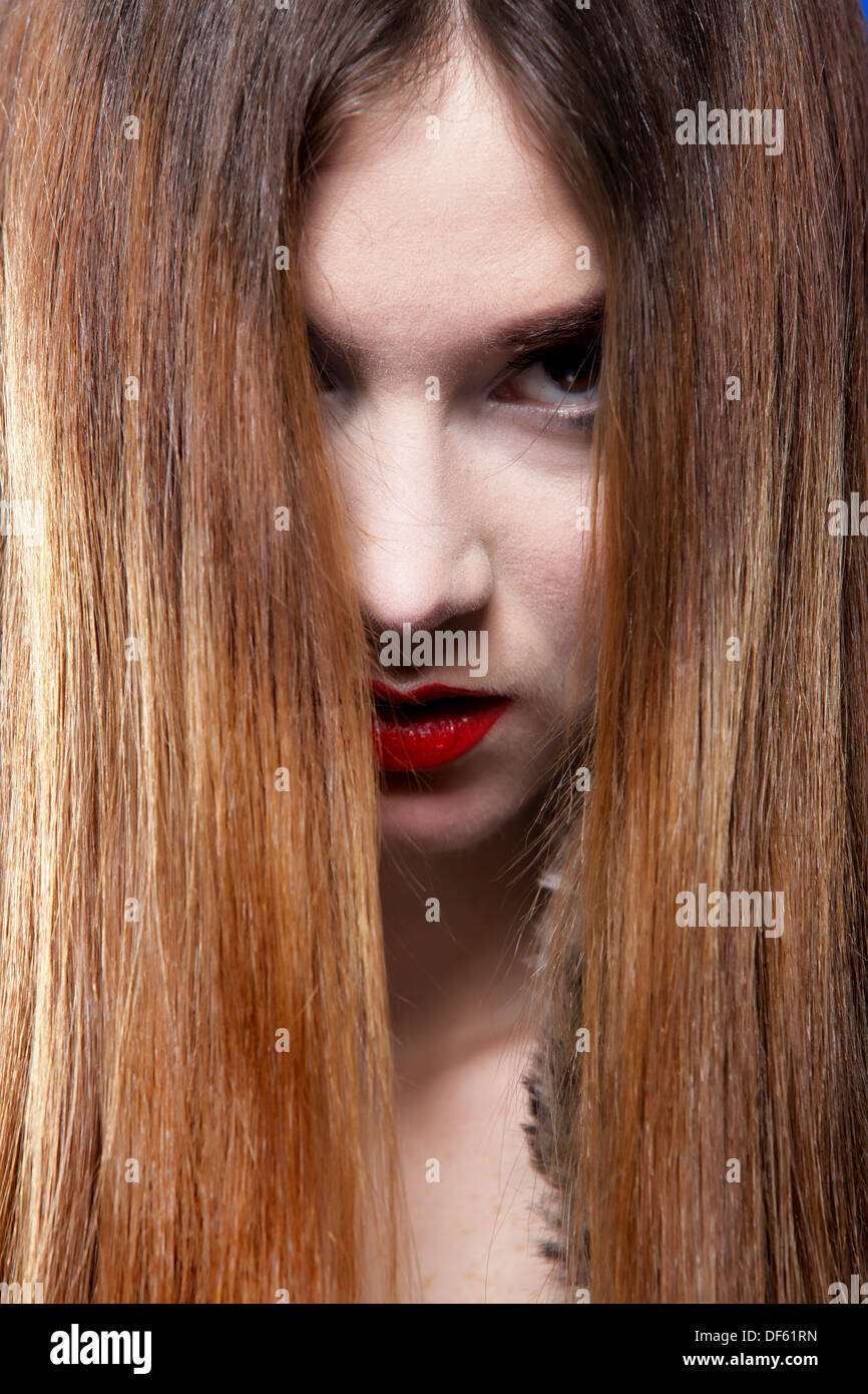 Portrait of young girl with hair covering her face. Studio shot. Secret ...