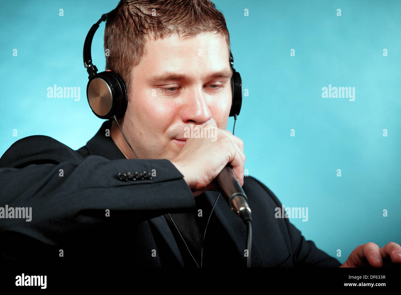 Young man singing into microphone. Happy karaoke signer studio shot ...