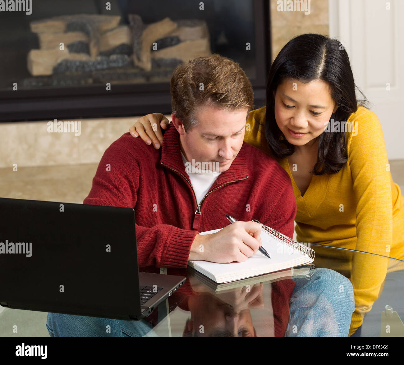 Photo of mature couple closely working together at home with fireplace ...