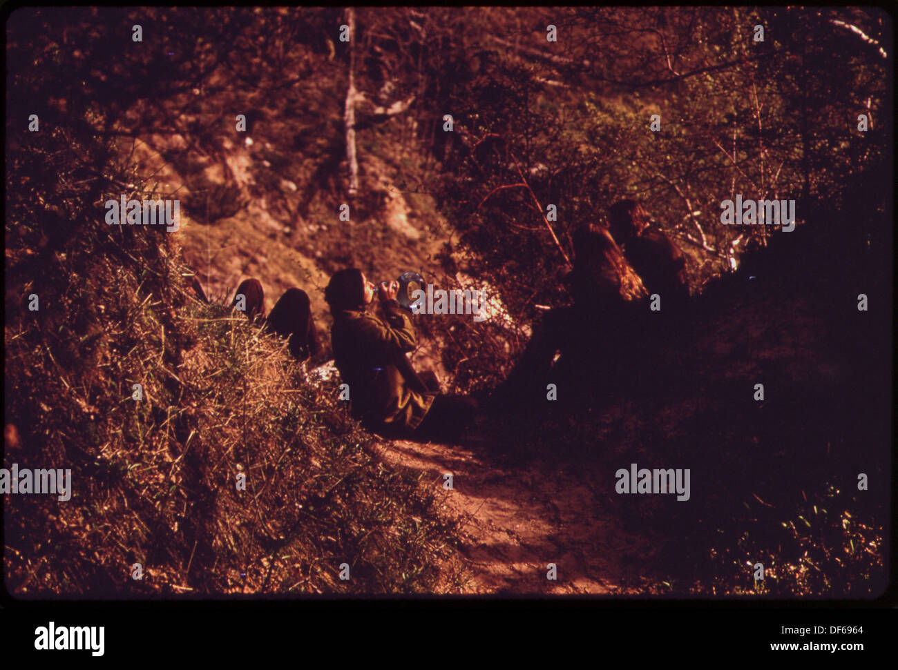 HIKERS REST ON CLIFF SIDE TRAIL AND SIP SPRING WATER FROM OLD WINE JUG ...