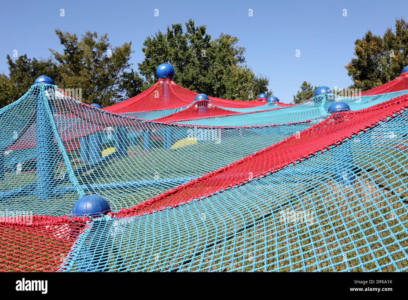 Blue and red spider net construction on kids playground Stock Photo - Alamy