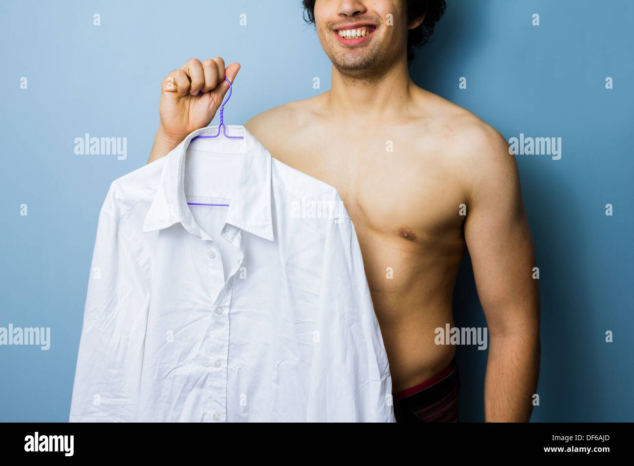 Young man is holding his clean white shirt Stock Photo - Alamy