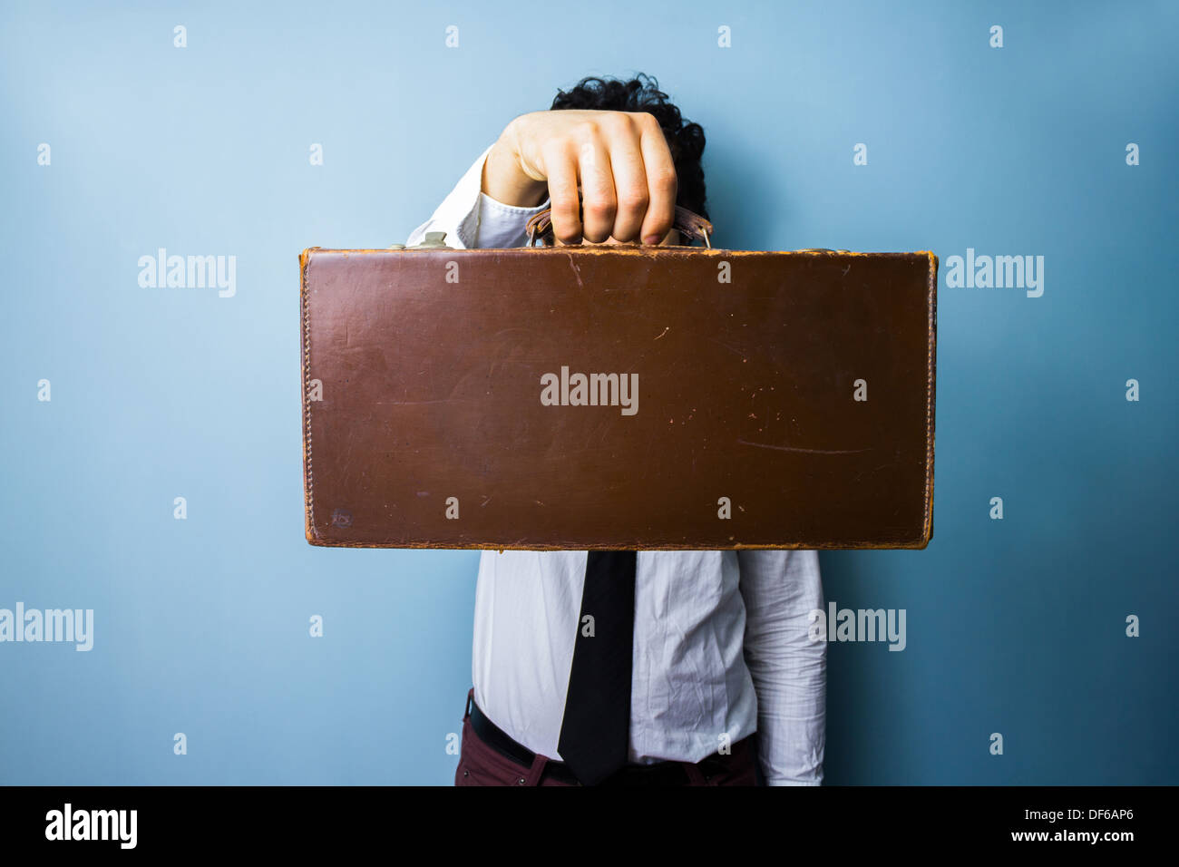 Young businessman holding an old briefcase in front of his face Stock ...