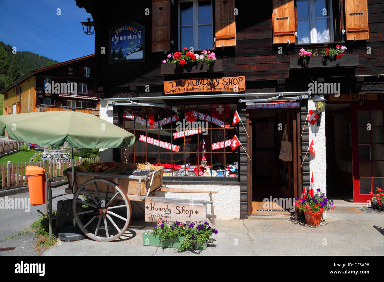 A shop in a Swiss chalet with a cart and window boxes Stock Photo - Alamy