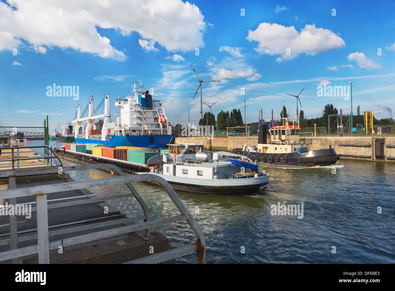 Cargo ship and container barges passing the Zandvliet lock in Antwerp ...