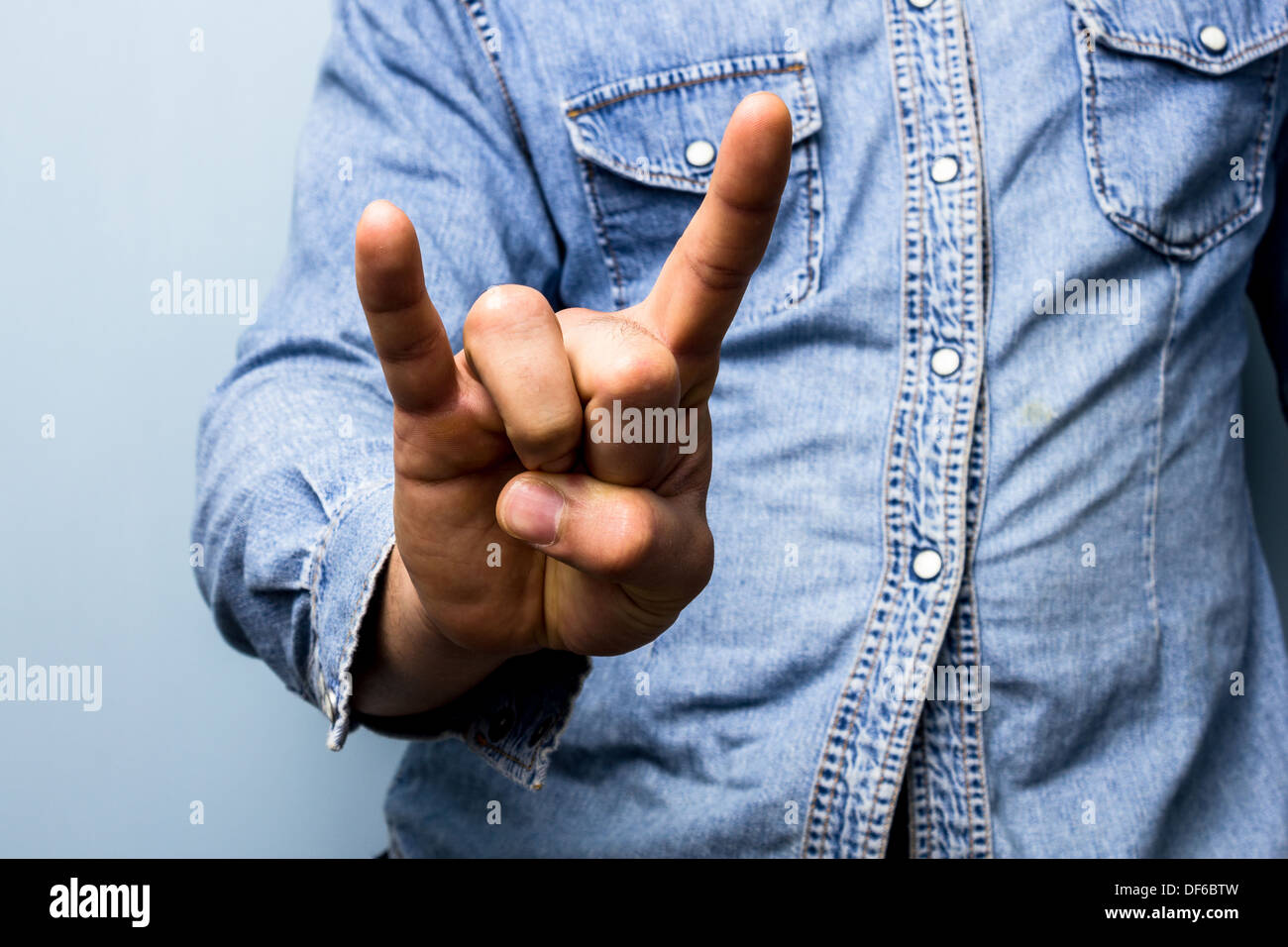 Young man displaying heavy metal salutation with his hand Stock Photo ...