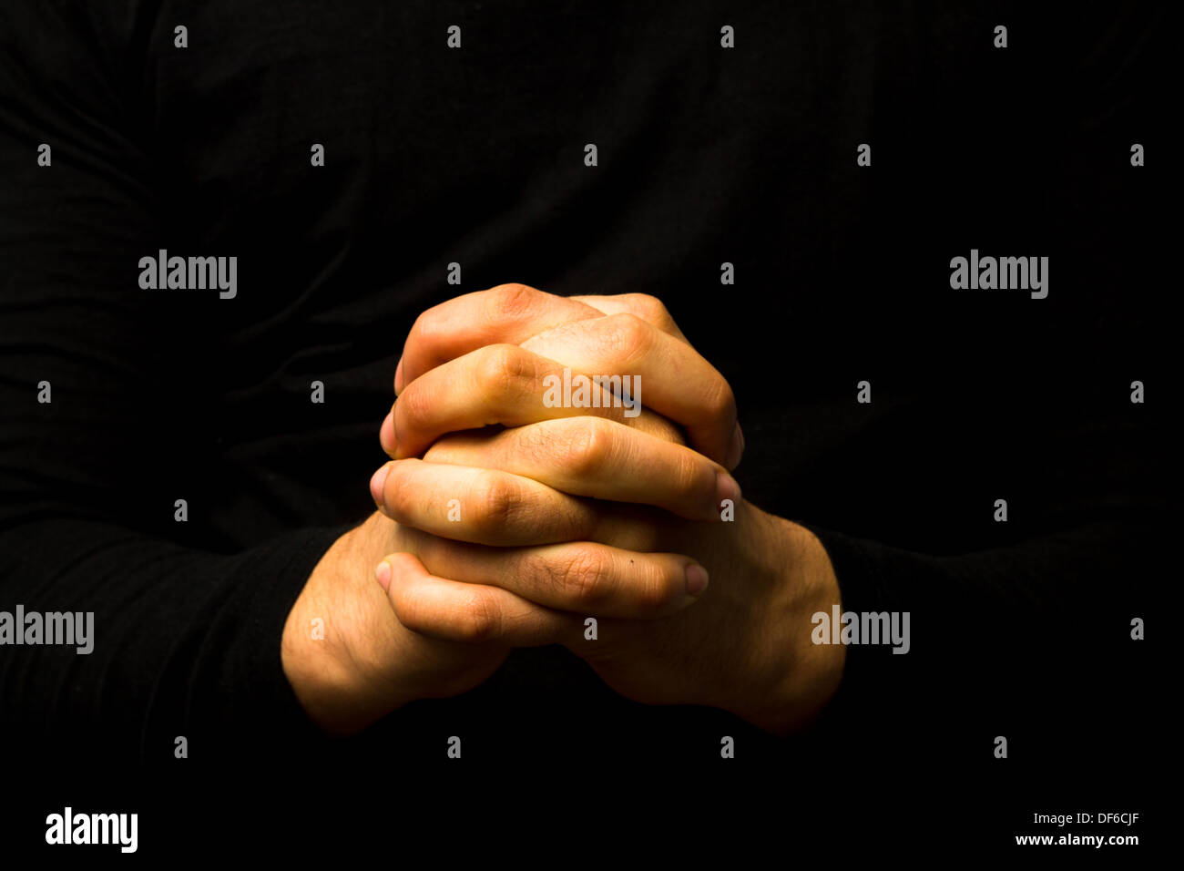 Young man's hands folded in prayer Stock Photo - Alamy