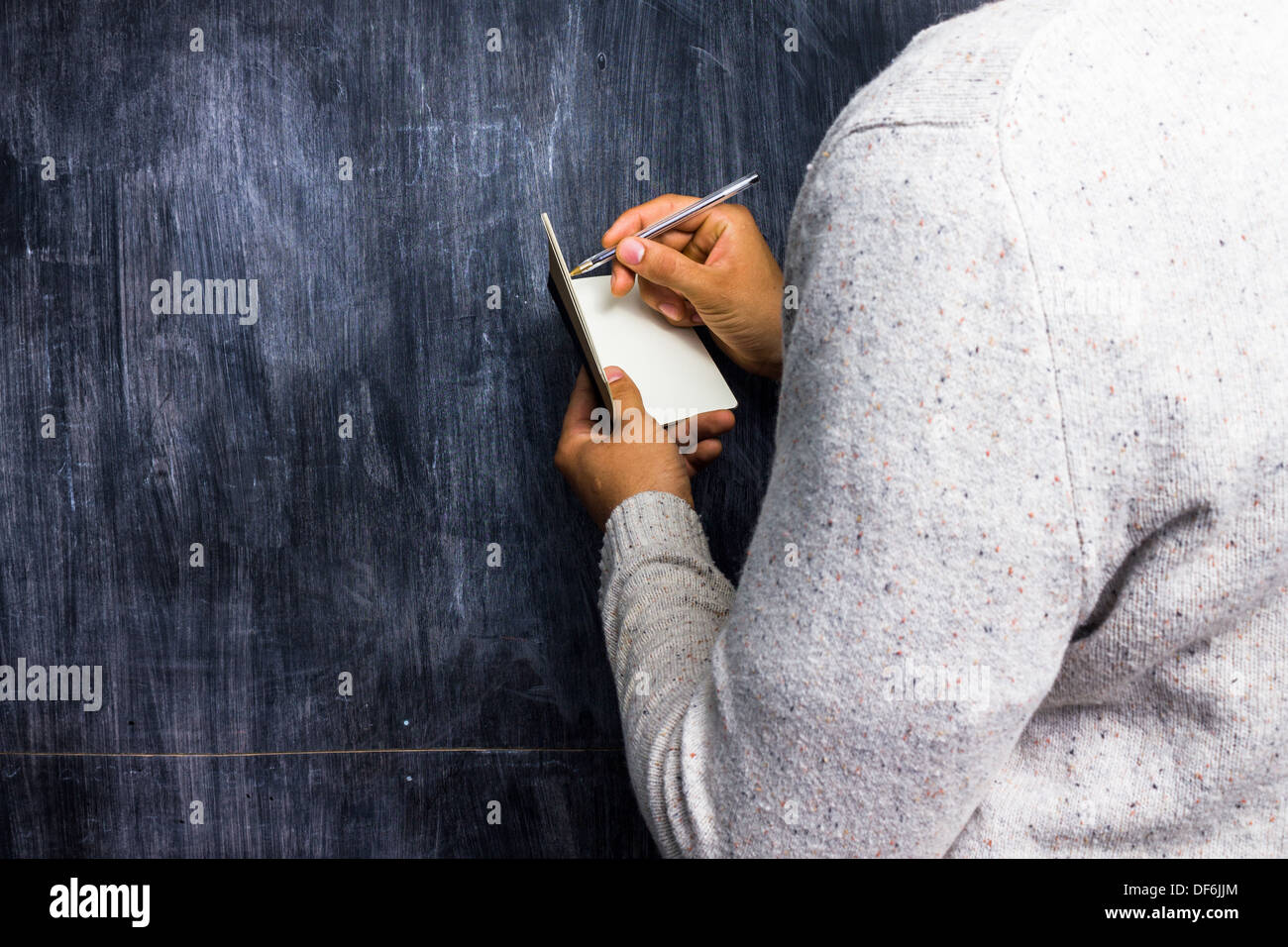 Rear view of young man taking notes in front of a blackboard Stock ...