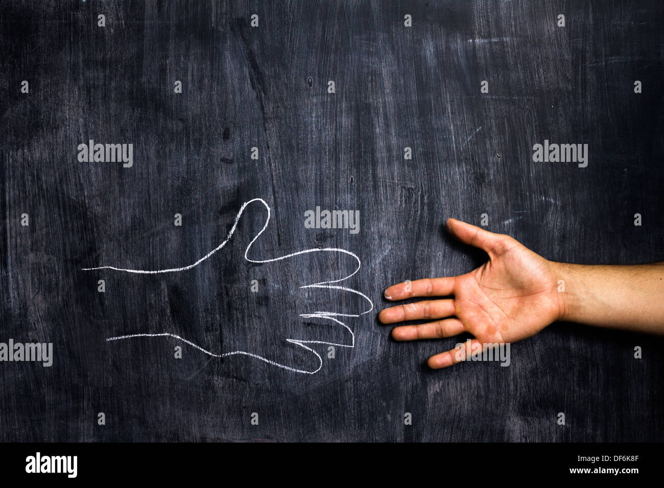 Hand by chalk drawing of hand on blackboard Stock Photo - Alamy