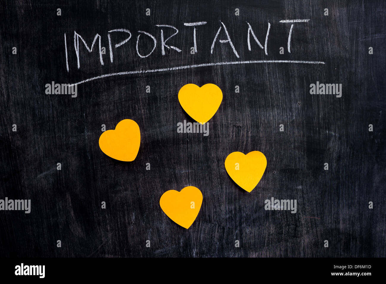 Heart shaped paper notes on blackboard with important written above ...