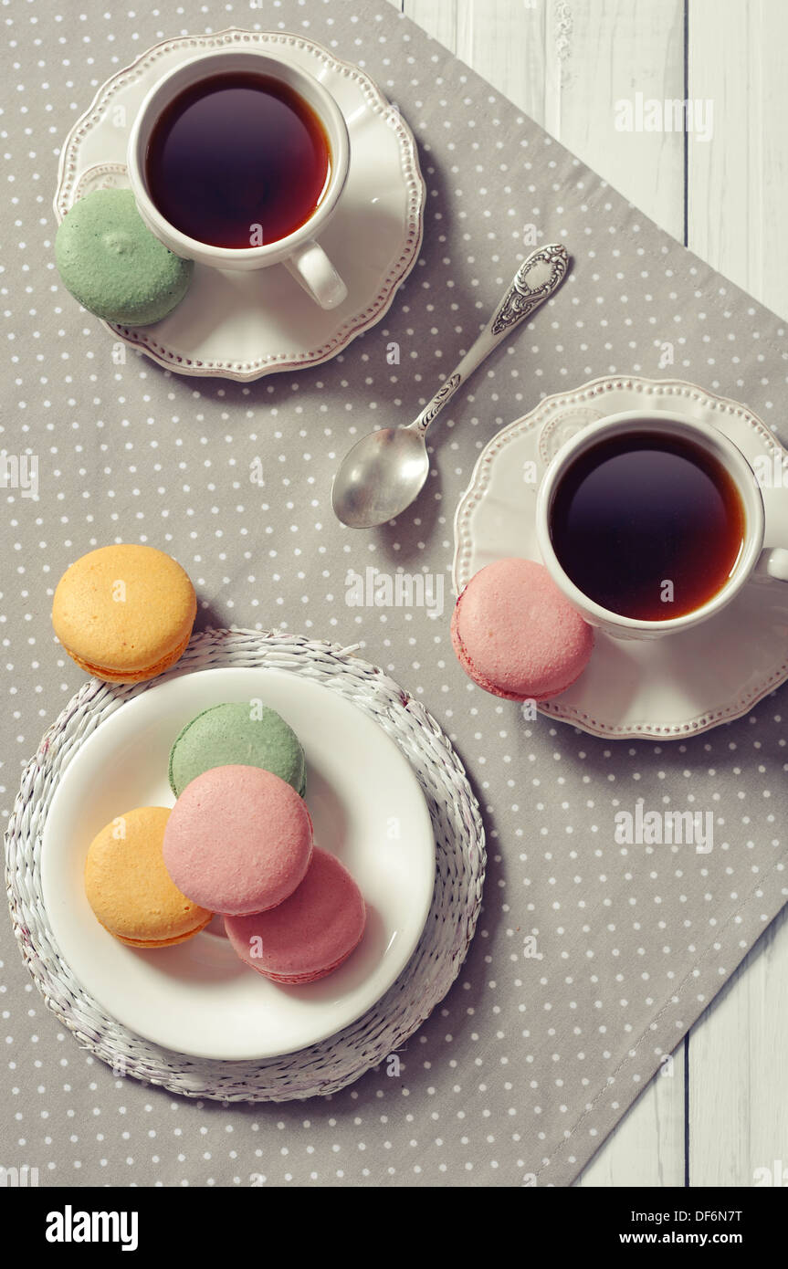 Traditional french pastry - macaroon with cup of tea on beige ...