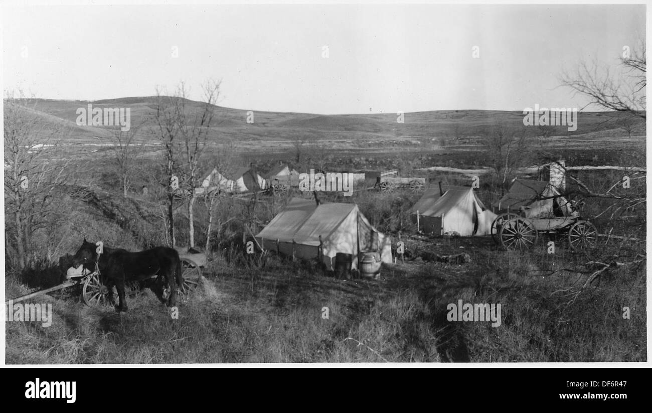 This photograph offers an overview of an Indian camp, likely ...