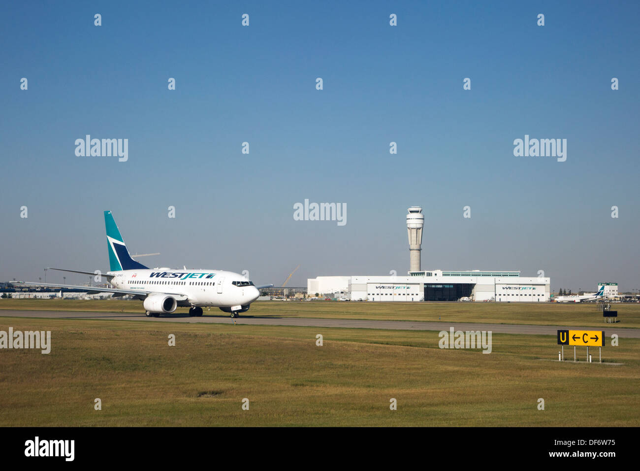 Westjet Boeing 737 jet on the runway in front of their hangar and the ...