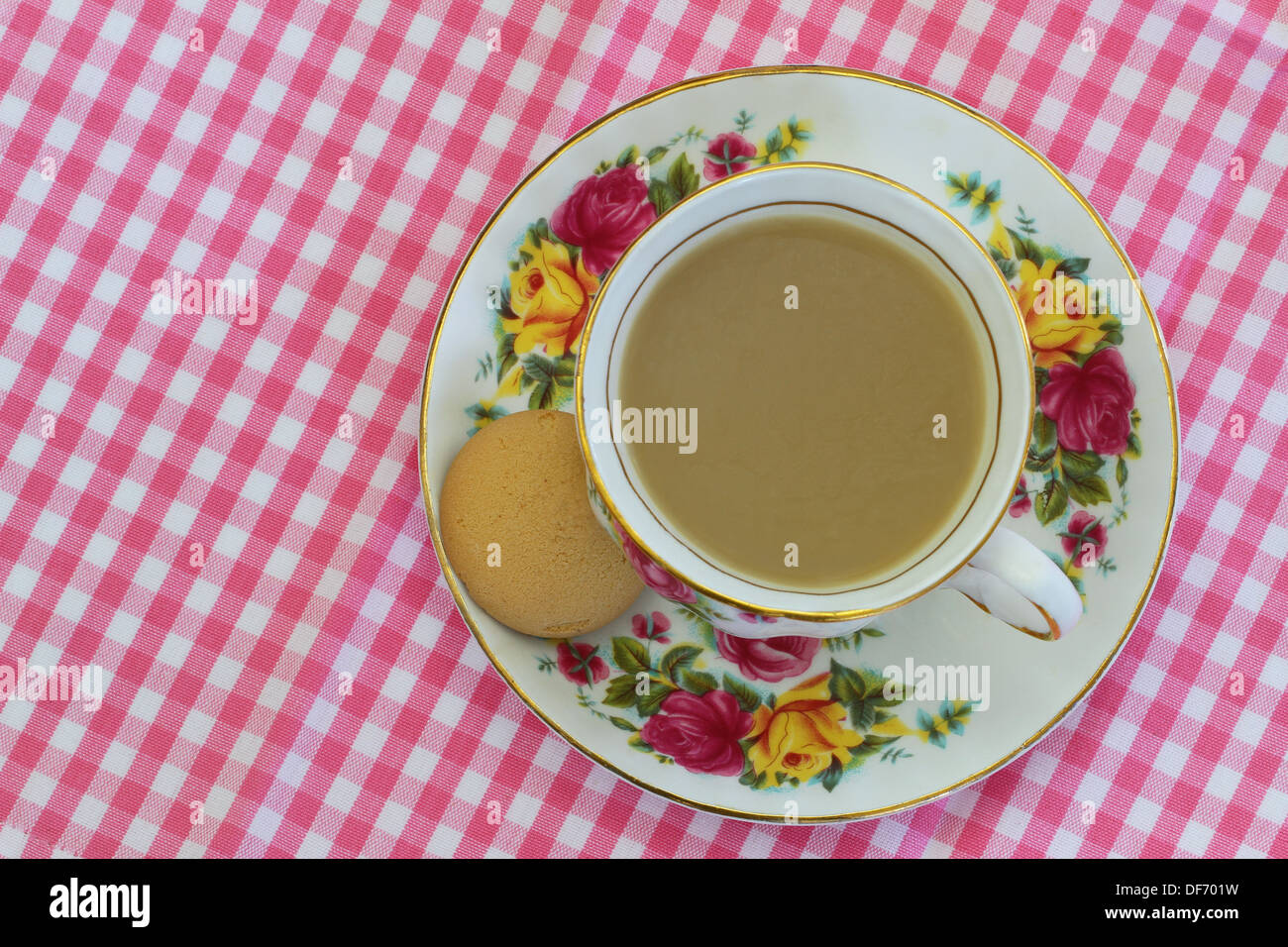 Tea in vintage porcelain cup on pink and white checkered cloth with ...