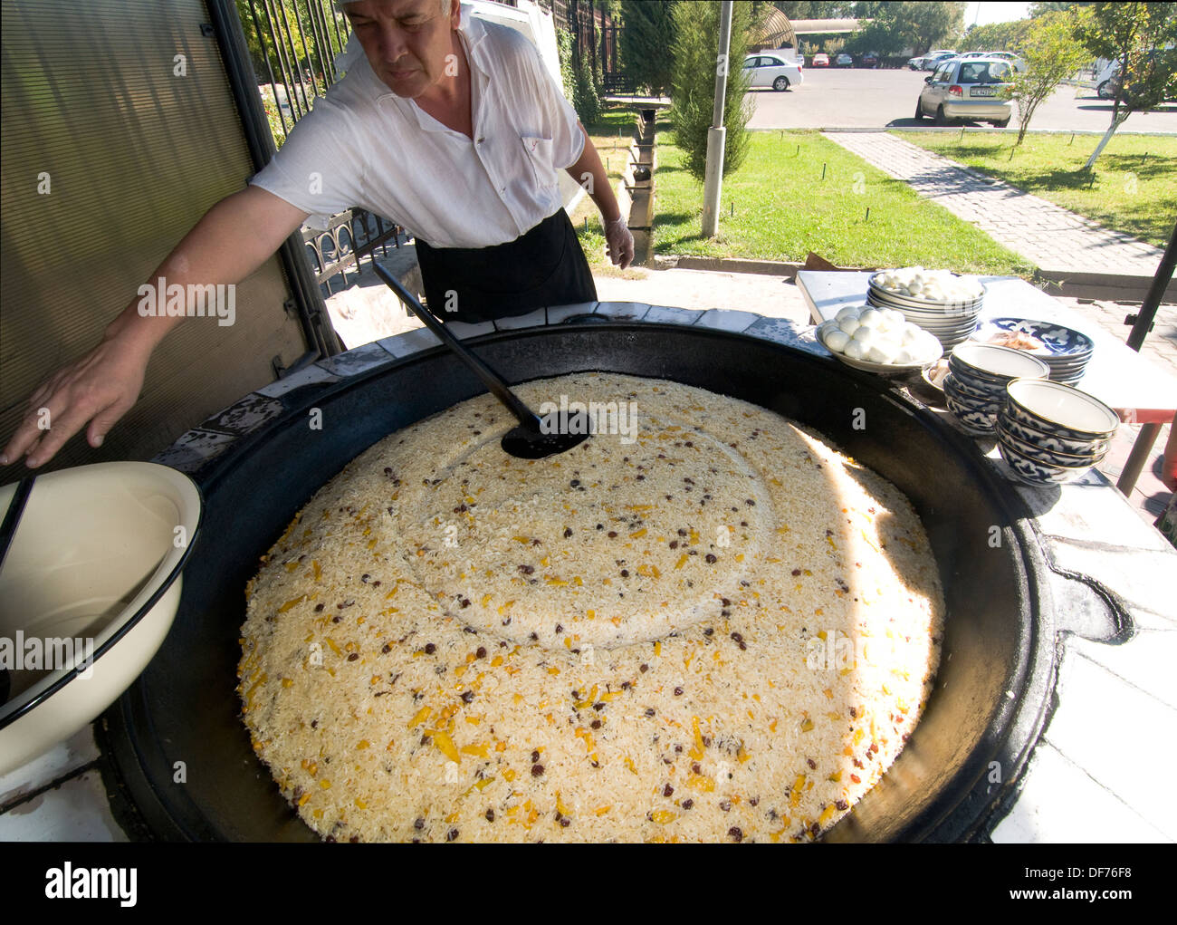 A big pot of Plov , a traditional Uzbek rice dish, being prepared at ...