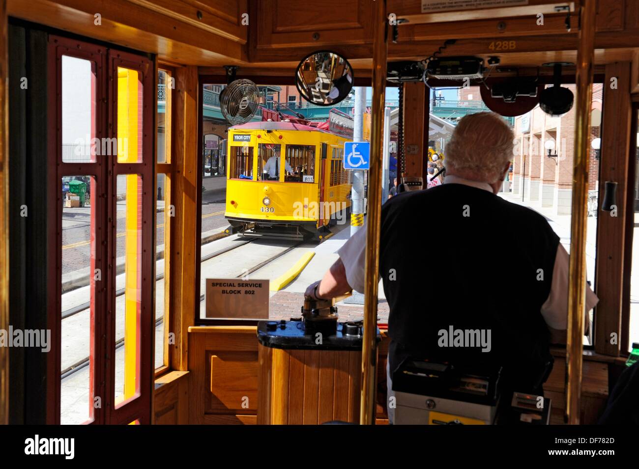 Conductor runs yellow historic trolley on track in Ybor City Tampa ...
