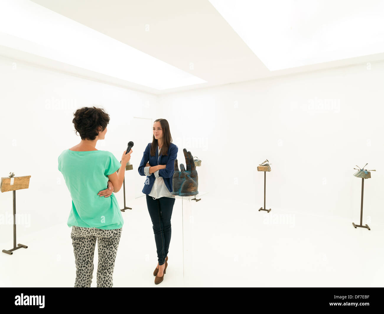 female reporter interviewing a woman while attending an art exhibition ...