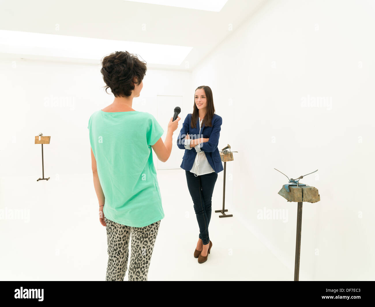 female reporter interviewing a caucasian woman at an art exhibition ...