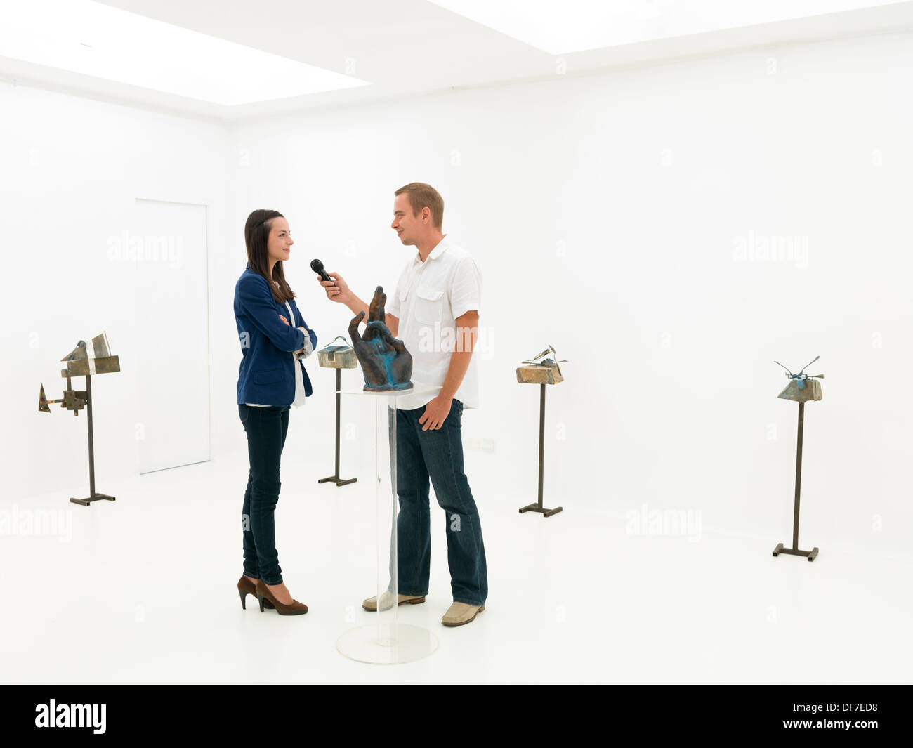 male reporter interviewing a woman in an art gallery Stock Photo - Alamy