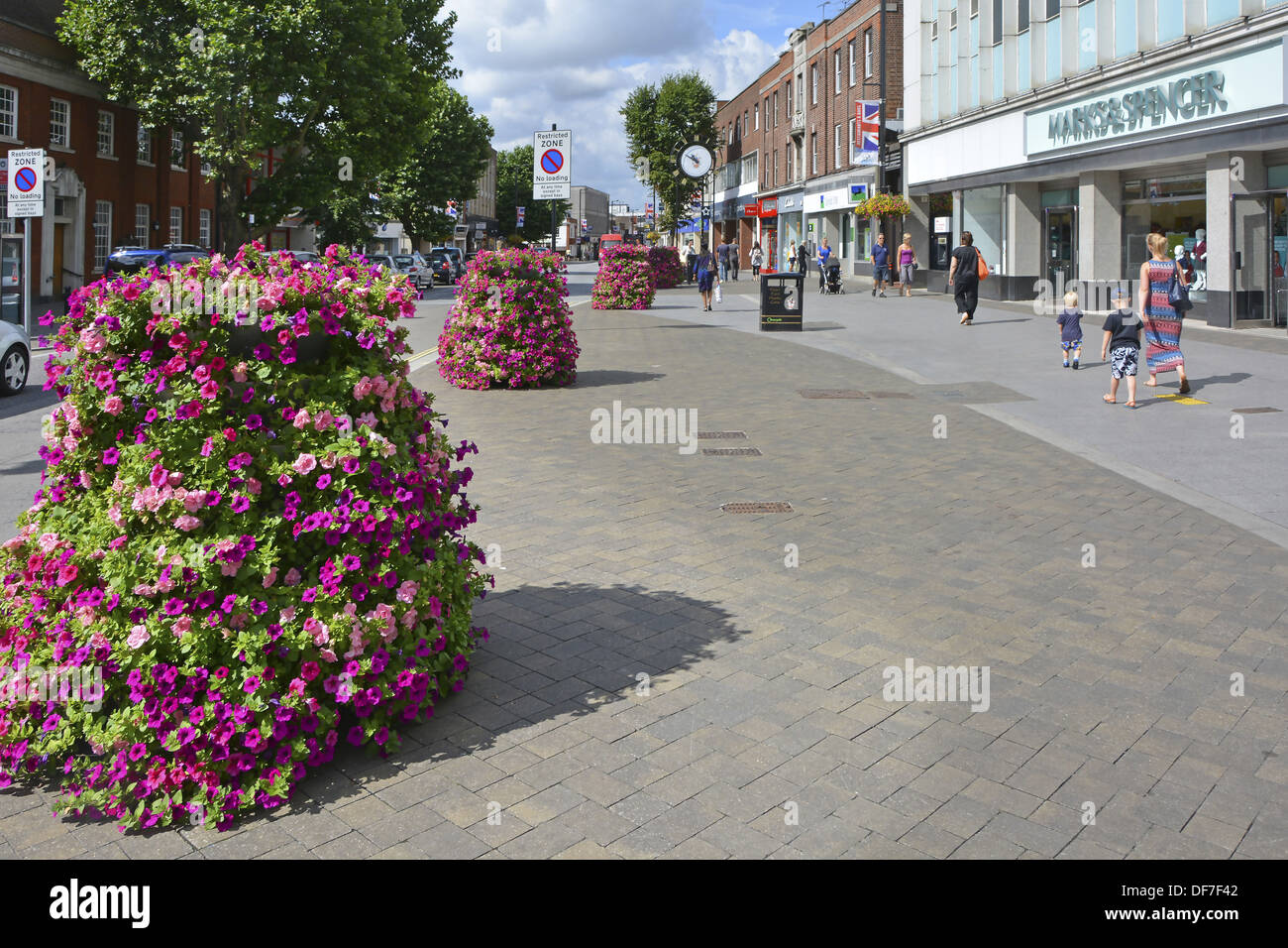 Wide pavement in Brentwood High Street with summer flower display and ...