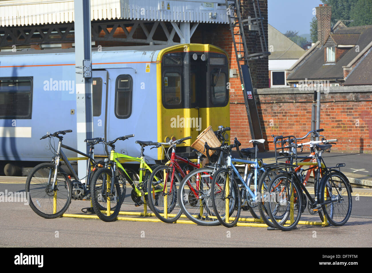 Commuters cycles left in bike racks on train station platform (train ...