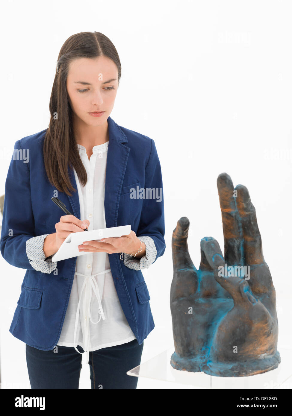 front view of woman taking notes about an artwork, in a museum Stock ...
