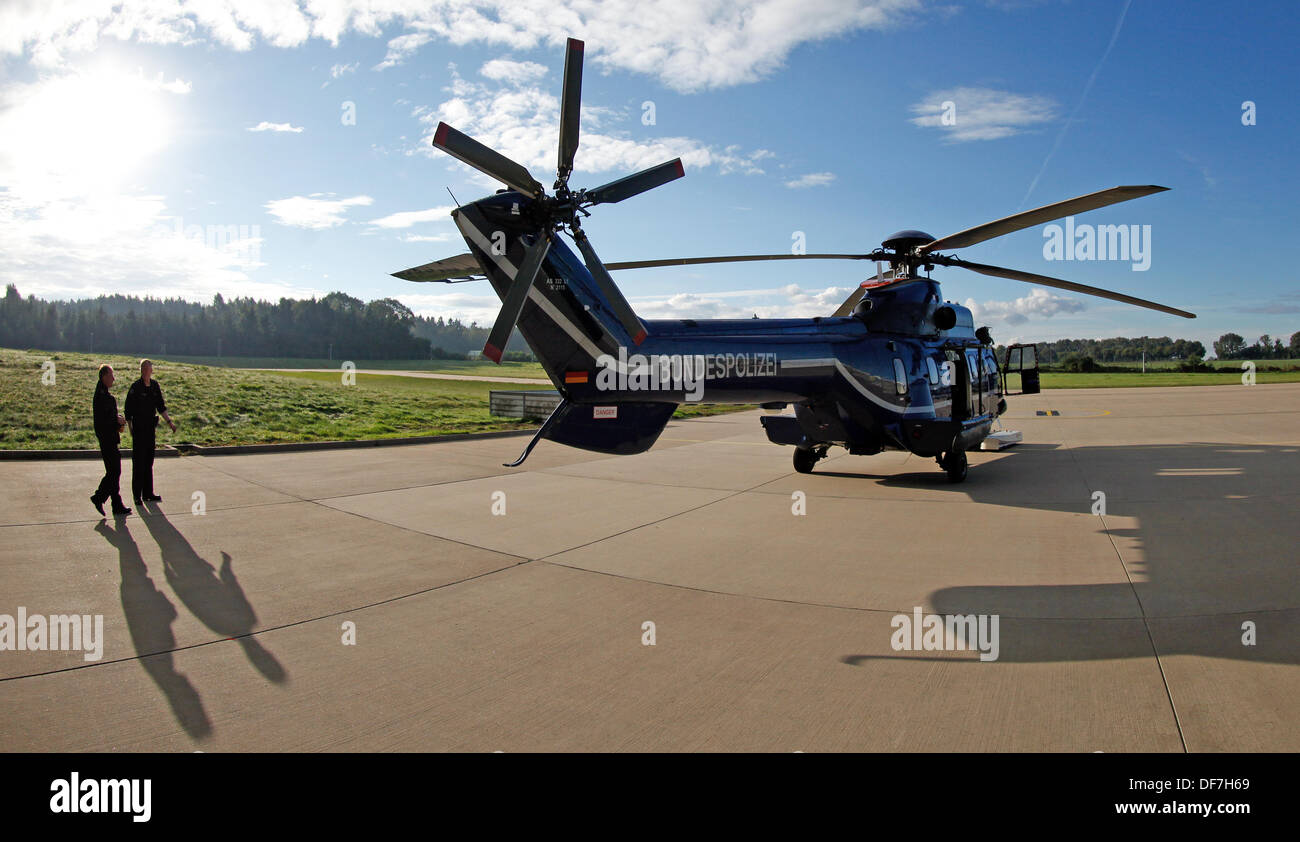 Pilots walk to a police helicopter at the federal police air force ...