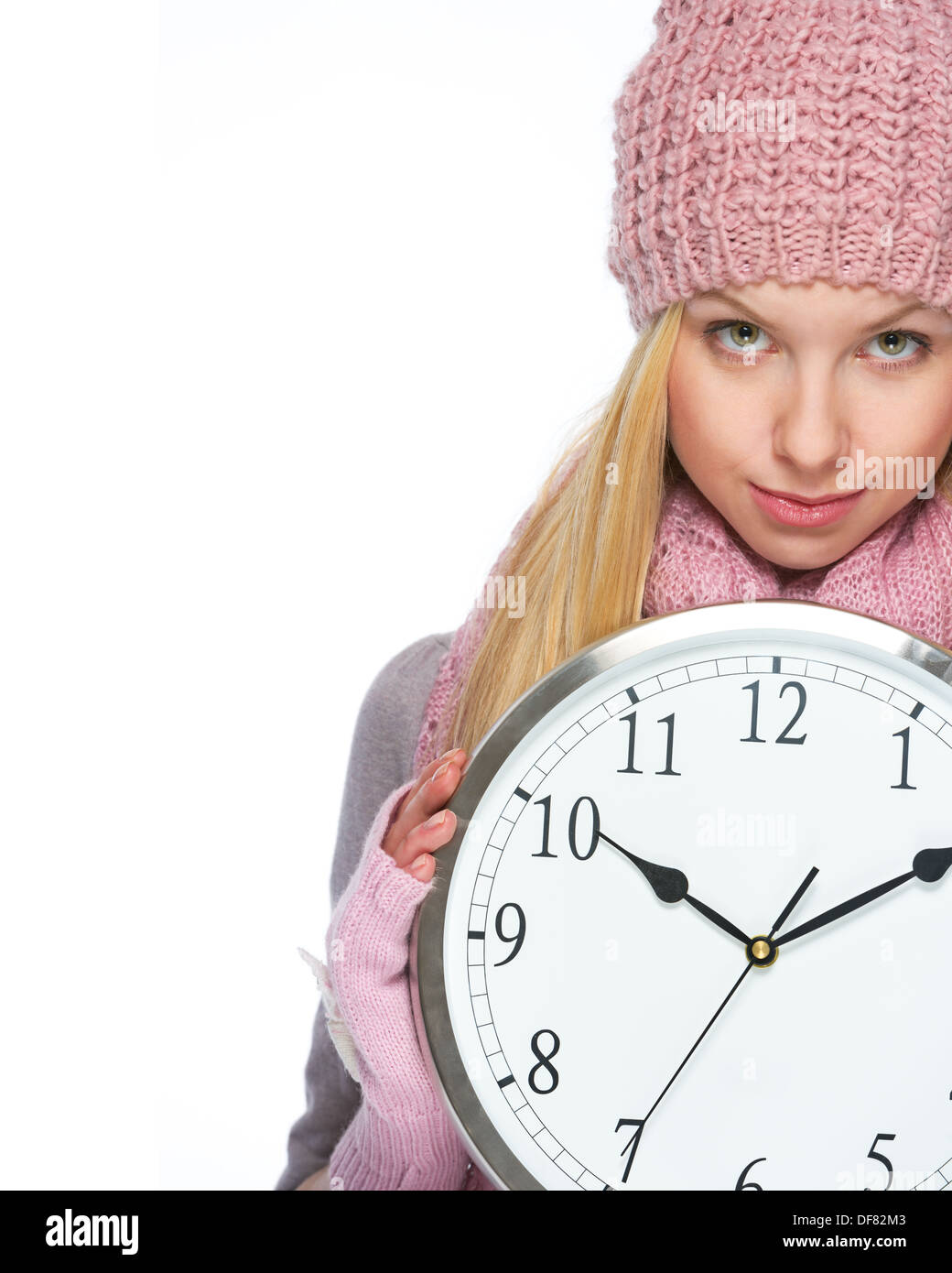 Girl in winter clothes showing clock Stock Photo - Alamy