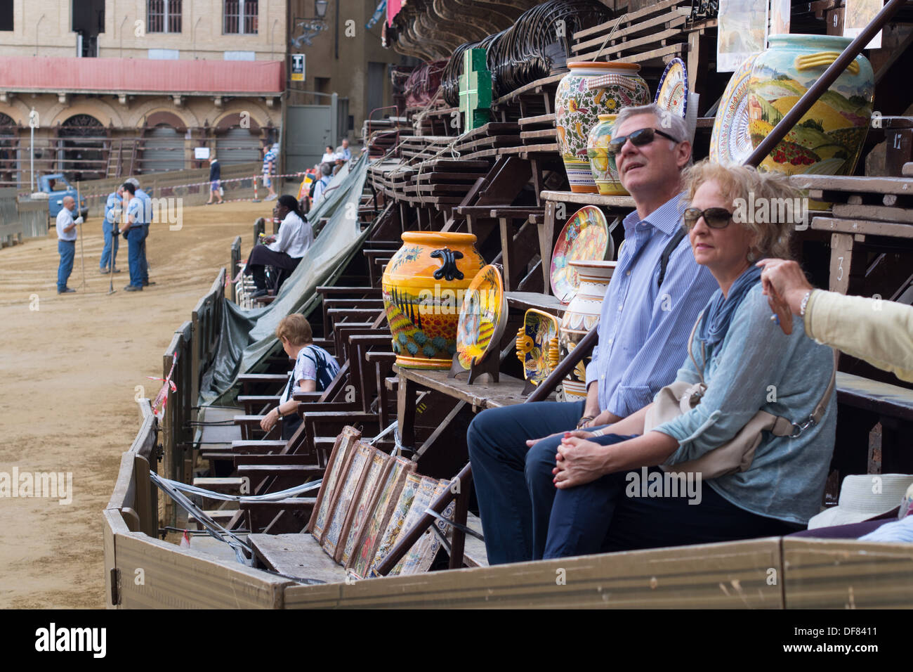 Couple at Il Campo (Medieval town square] in a grandstand over the dirt ...