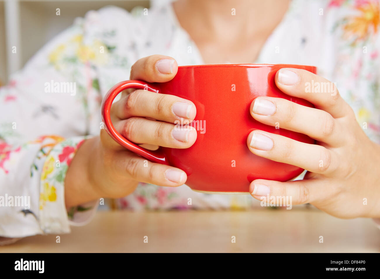 Female hands holding a big red coffee cup Stock Photo - Alamy