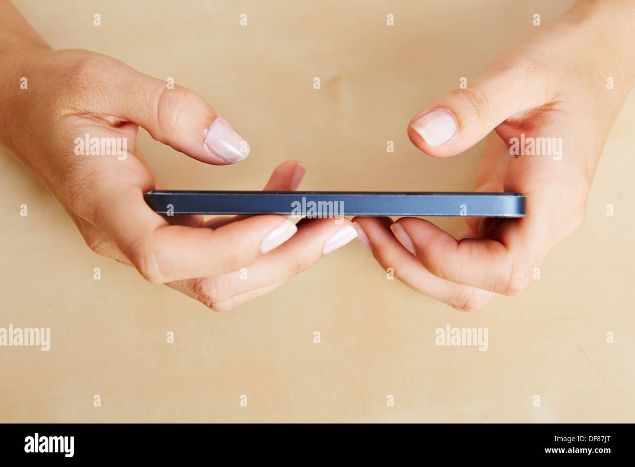 Two female hands using a smartphone from above Stock Photo - Alamy