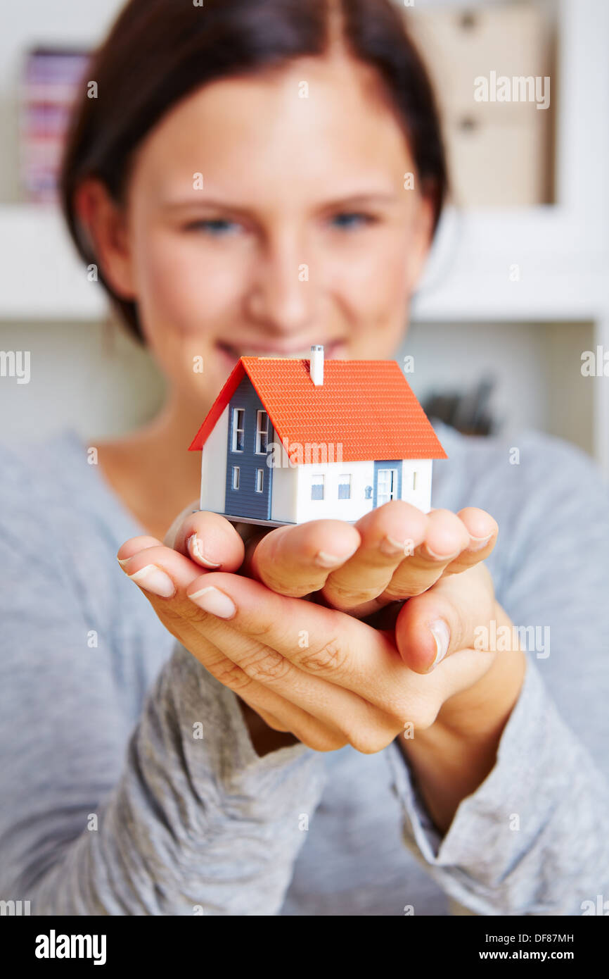 Happy woman holding a little house on her two hands Stock Photo - Alamy