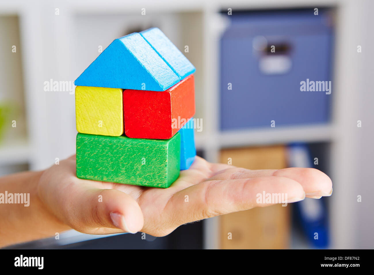 Female hand holding colorful house made of building blocks Stock Photo ...