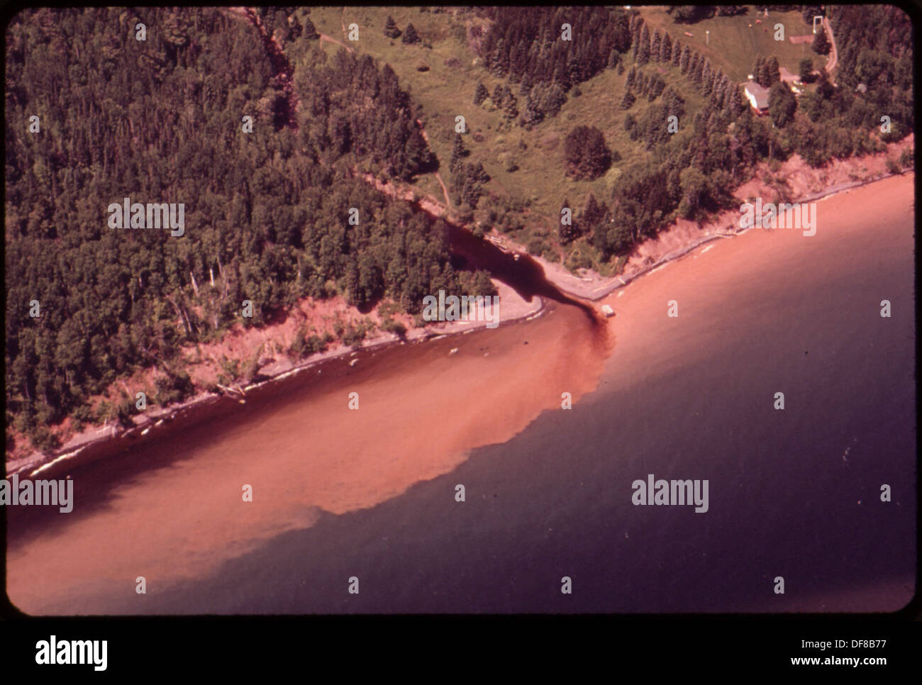An image capturing a small, muddy river flowing into Lake Superior ...