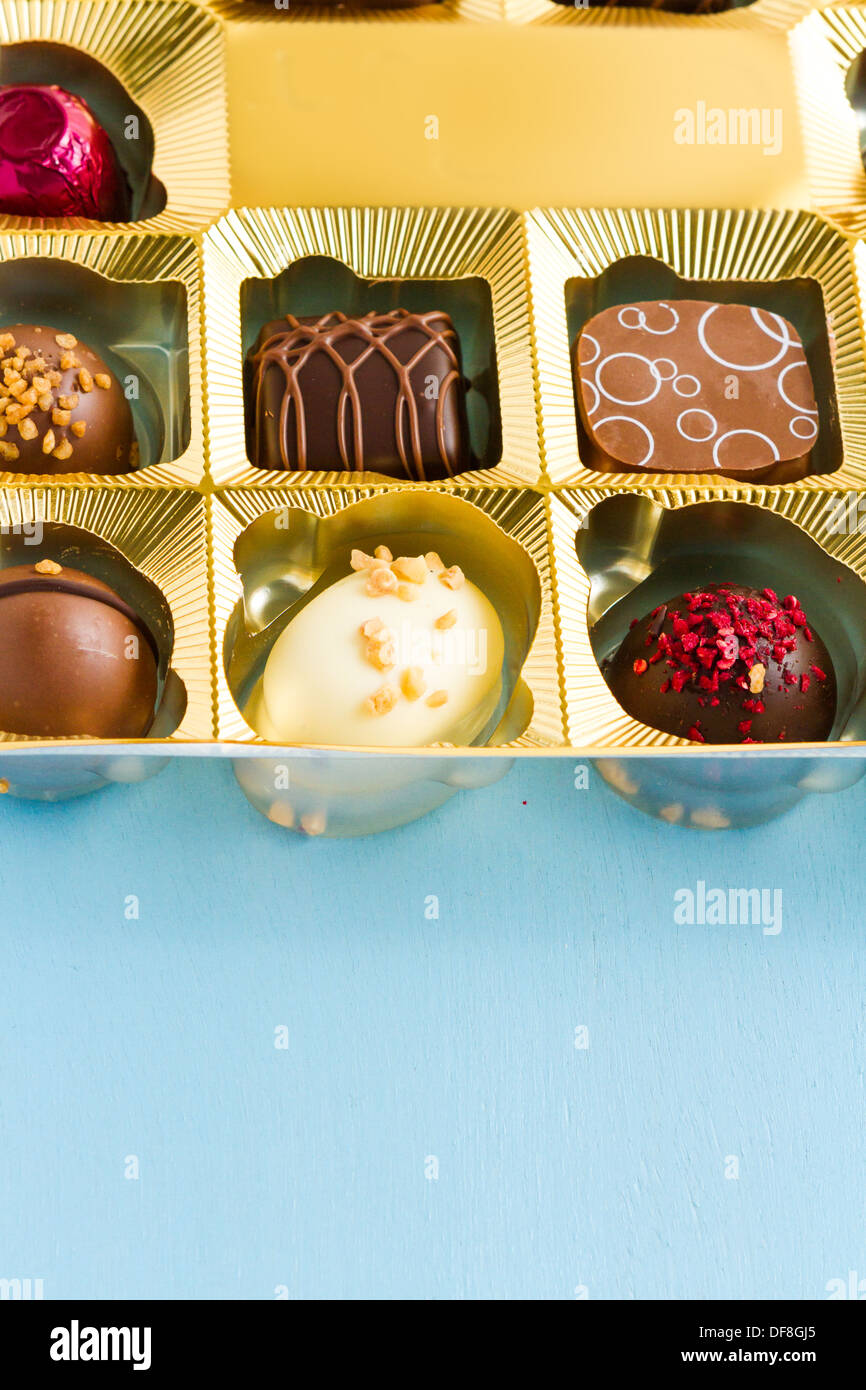 Gourmet chocolates in golden box on blue back ground Stock Photo - Alamy