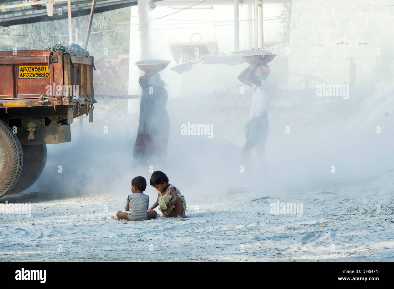 Indian children playing, surrounded by dust, unprotected, at a stone ...