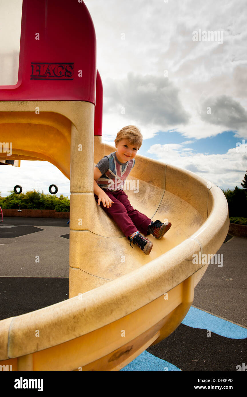 young boy on chute slide at play park having fun Stock Photo - Alamy