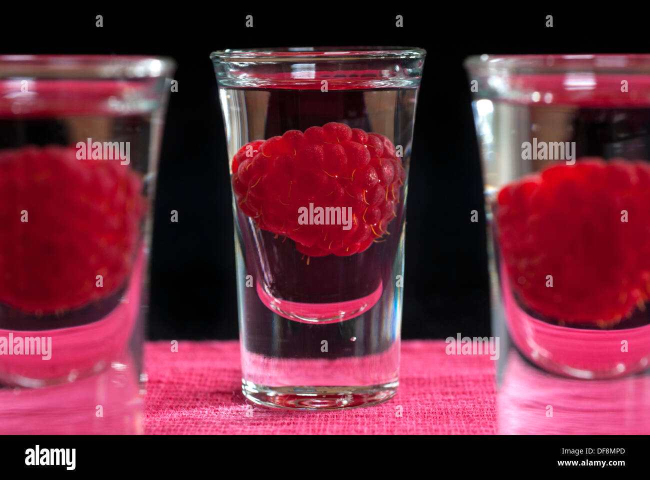 Raspberry shots on a red and black background Stock Photo - Alamy