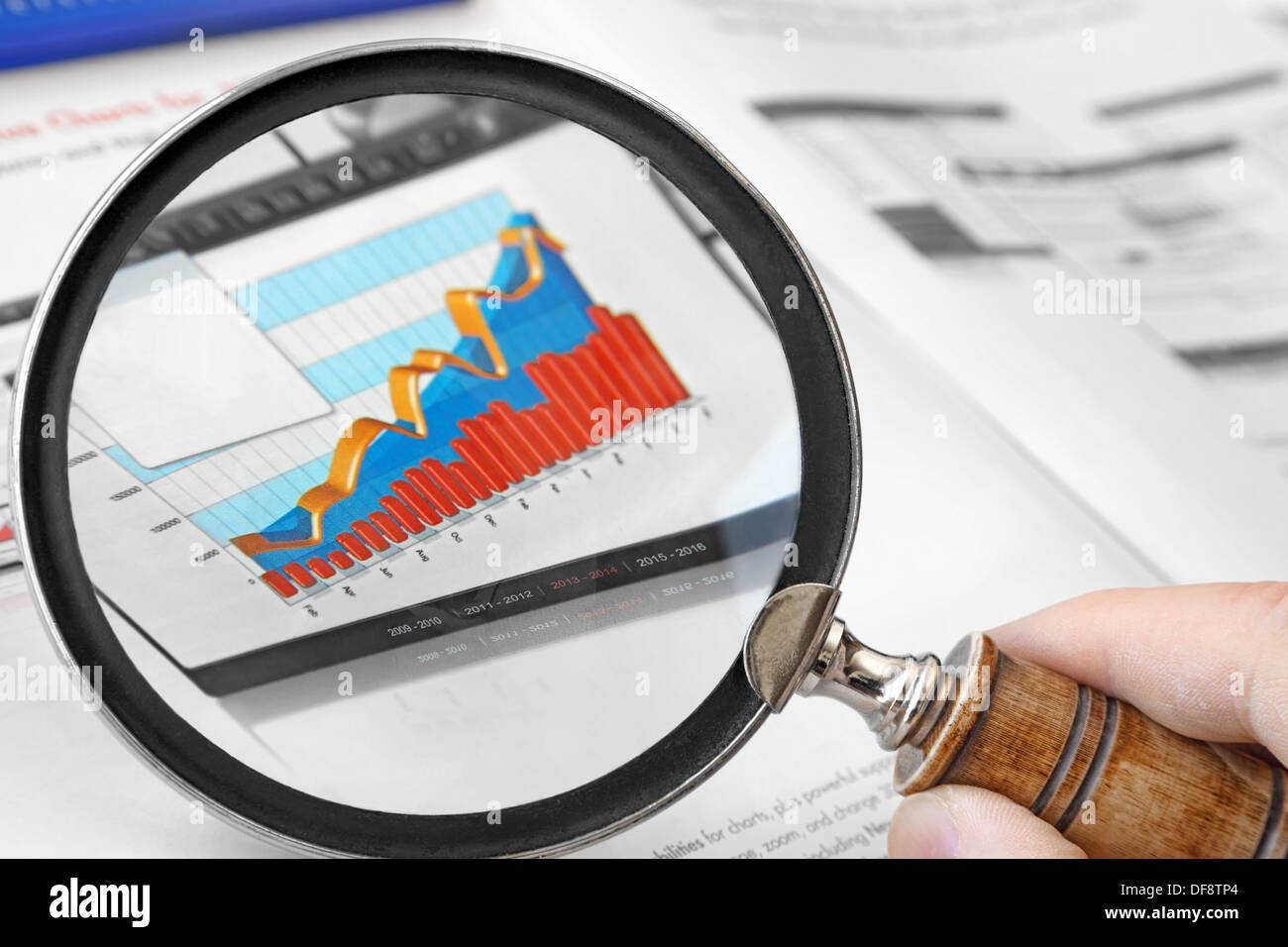 Magnifying Glass Over Financial Graph Stock Photo - Alamy