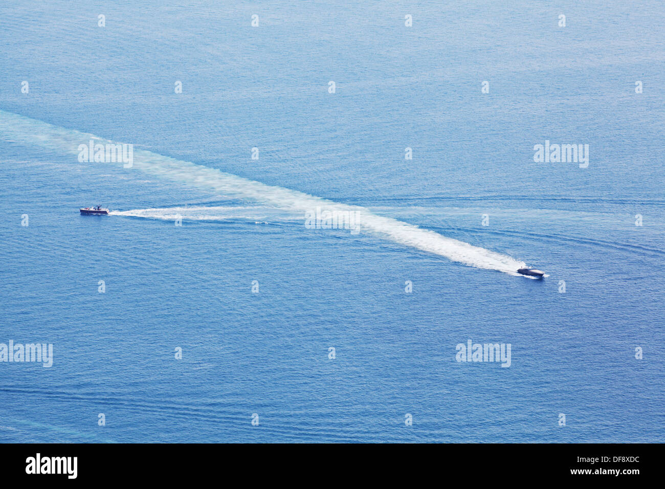 Intersection of two power boats in the ocean with long prop wash lines ...